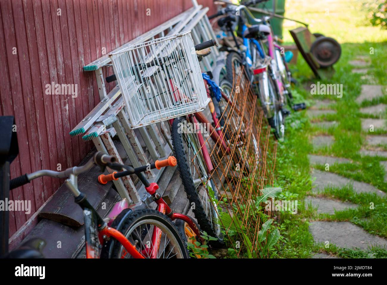 collection of old bicycles and household stuff in a messy backyard ...