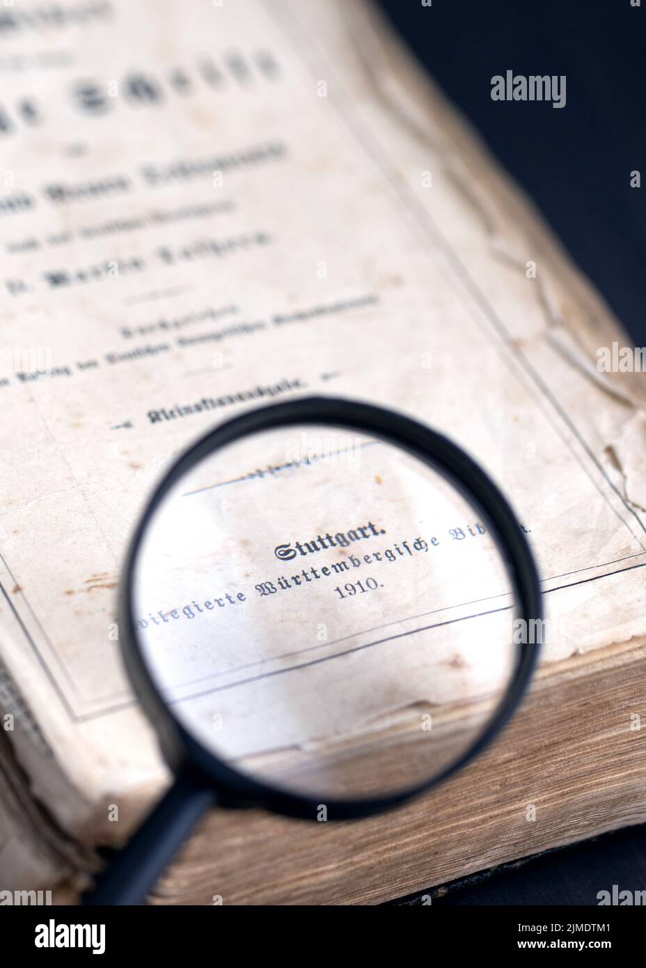Opening ancient bible, text reading through magnifying glass. Study of ...