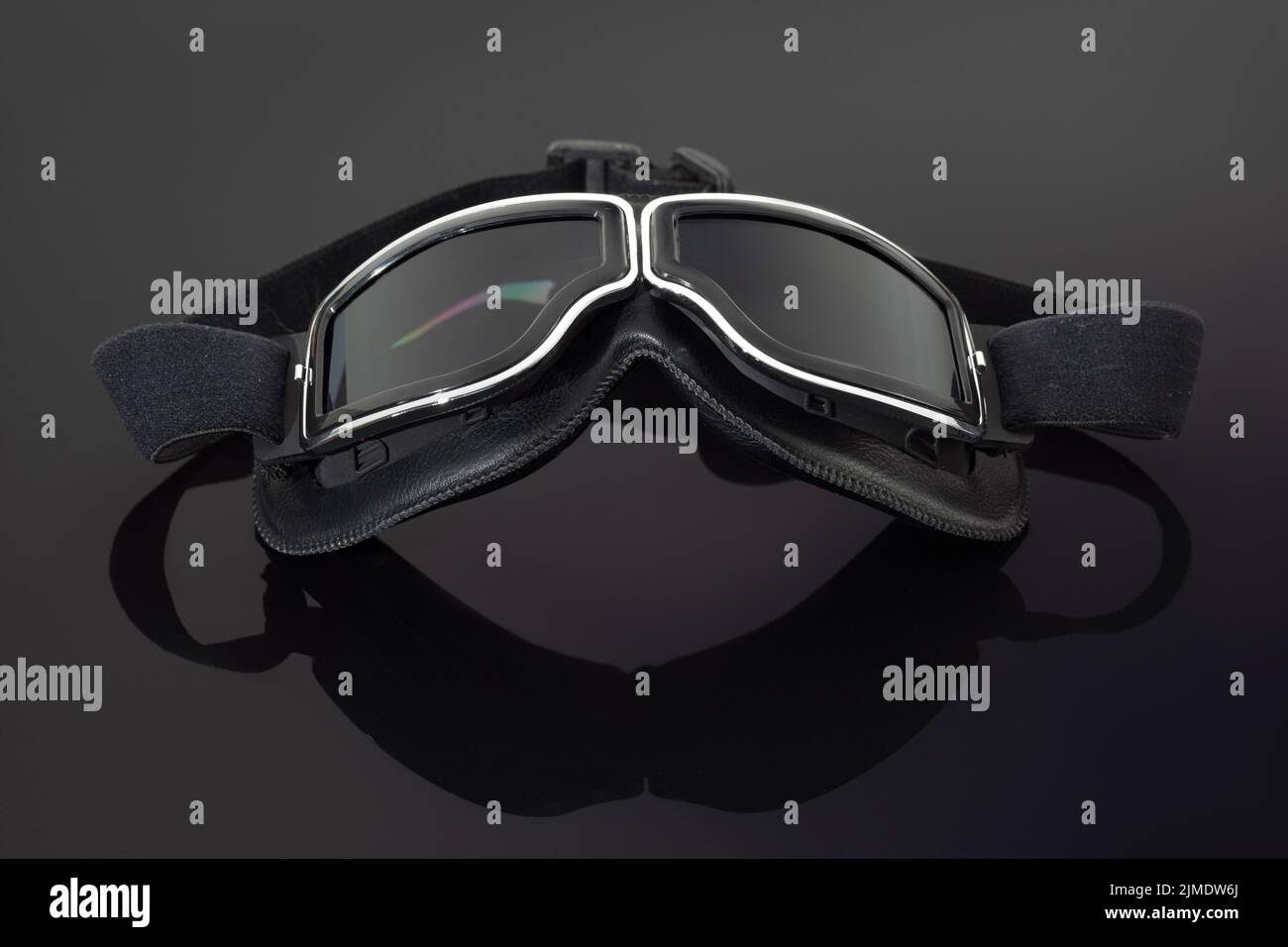 Black vintage motorcycle race goggles with reflection on mirrored black ...