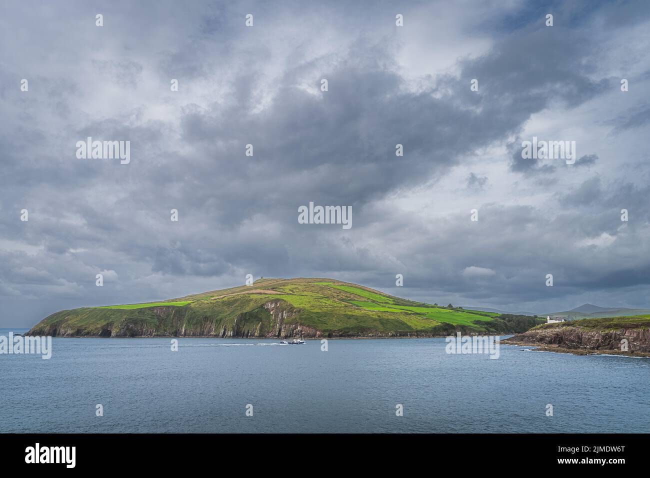 Dingle Lighthouse guiding fishing boats returning to the village Stock ...