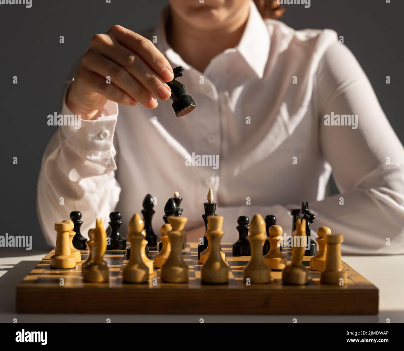 Faceless caucasian woman in white shirt playing chess Stock Photo - Alamy