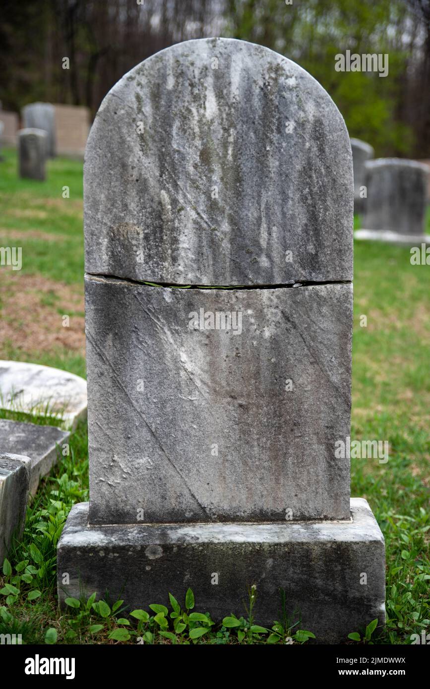 Tombstone grave stone cracked in half in green grassy cemetery Stock ...