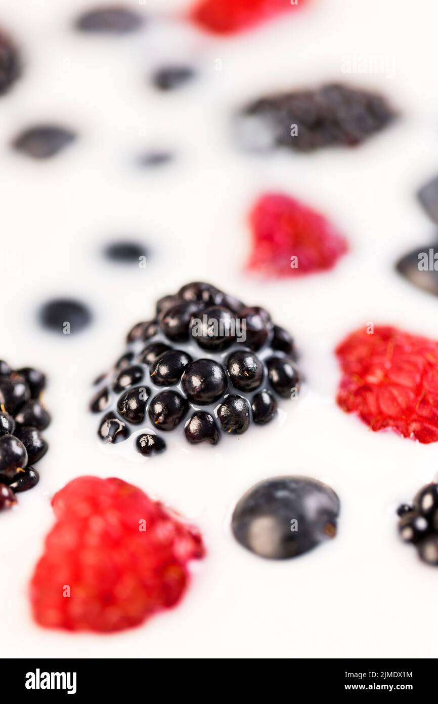 Fresh berries float in milk Stock Photo - Alamy