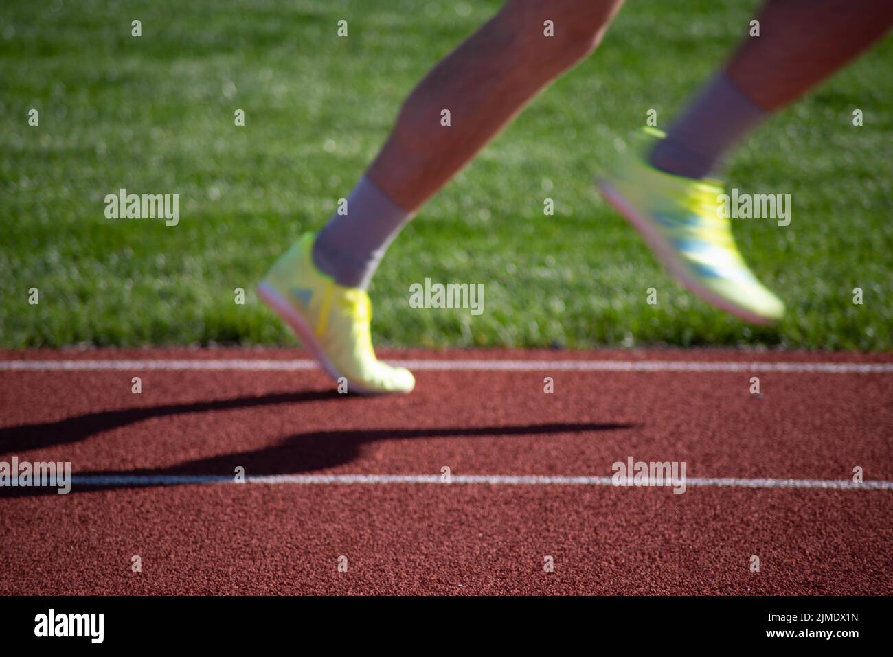 Motioned blurred feet in yellow sneakers run past the camera on a ...