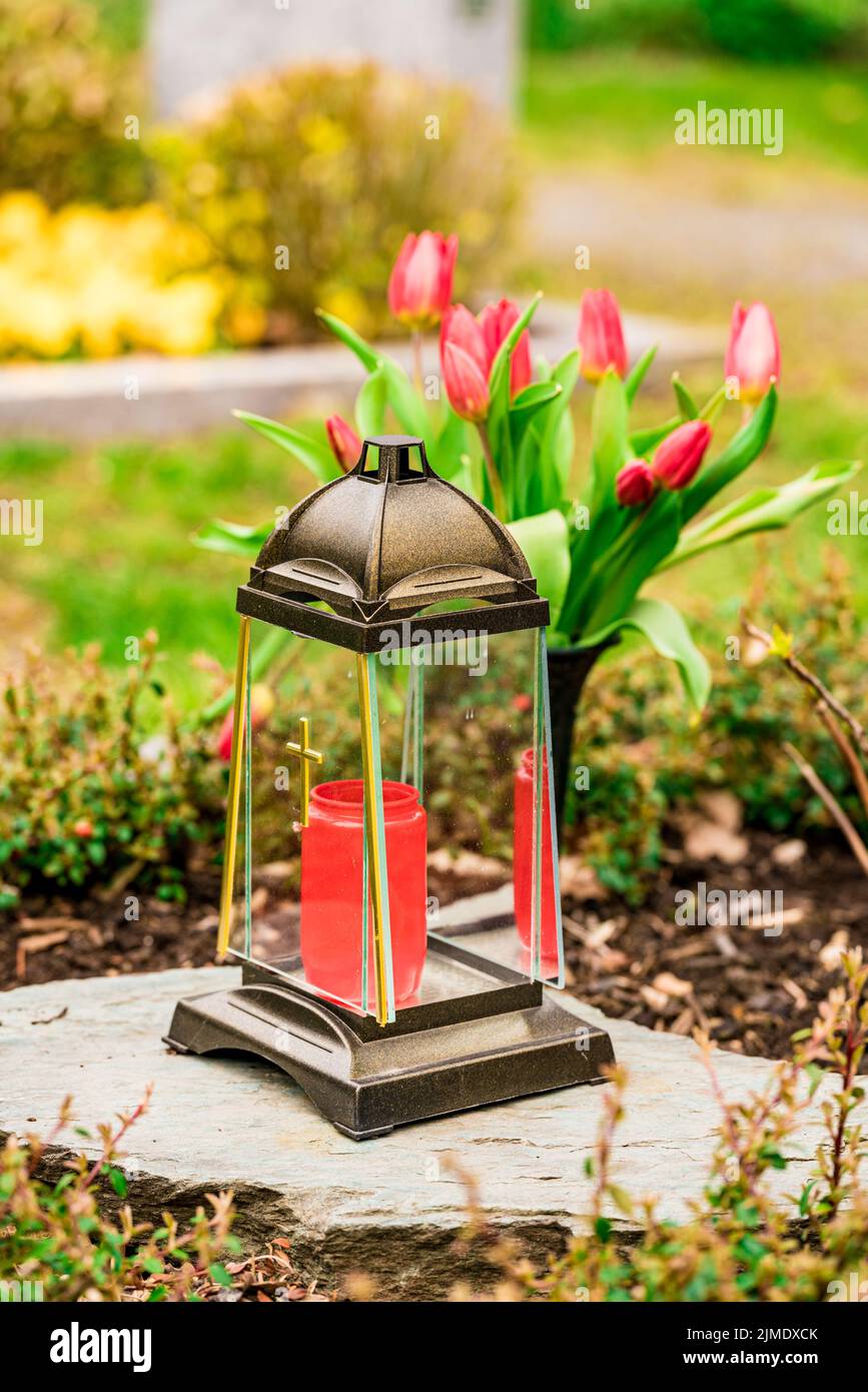 Memorial candles light on grave Stock Photo - Alamy