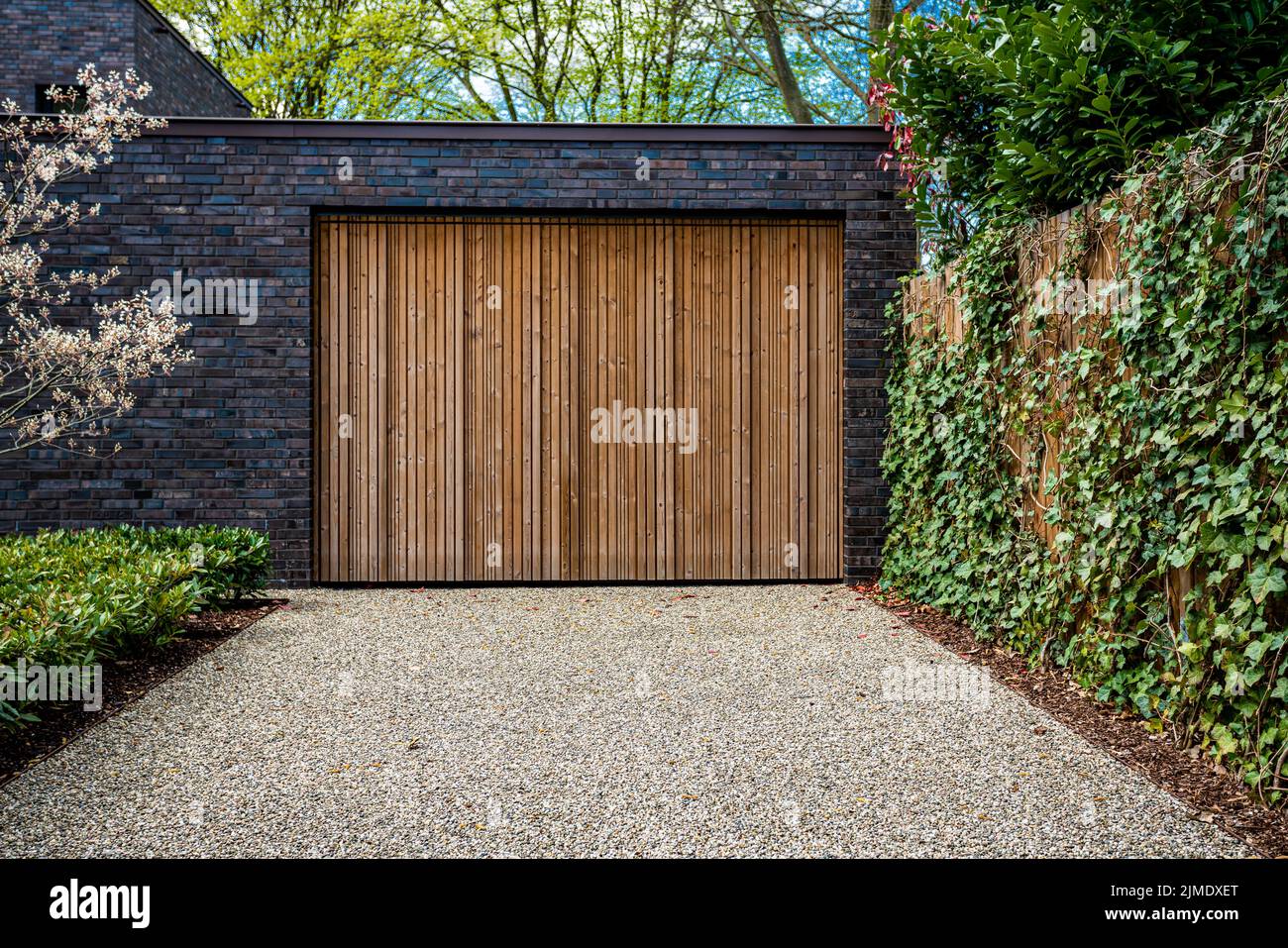 Wide garage door and concrete driveway in front Stock Photo - Alamy