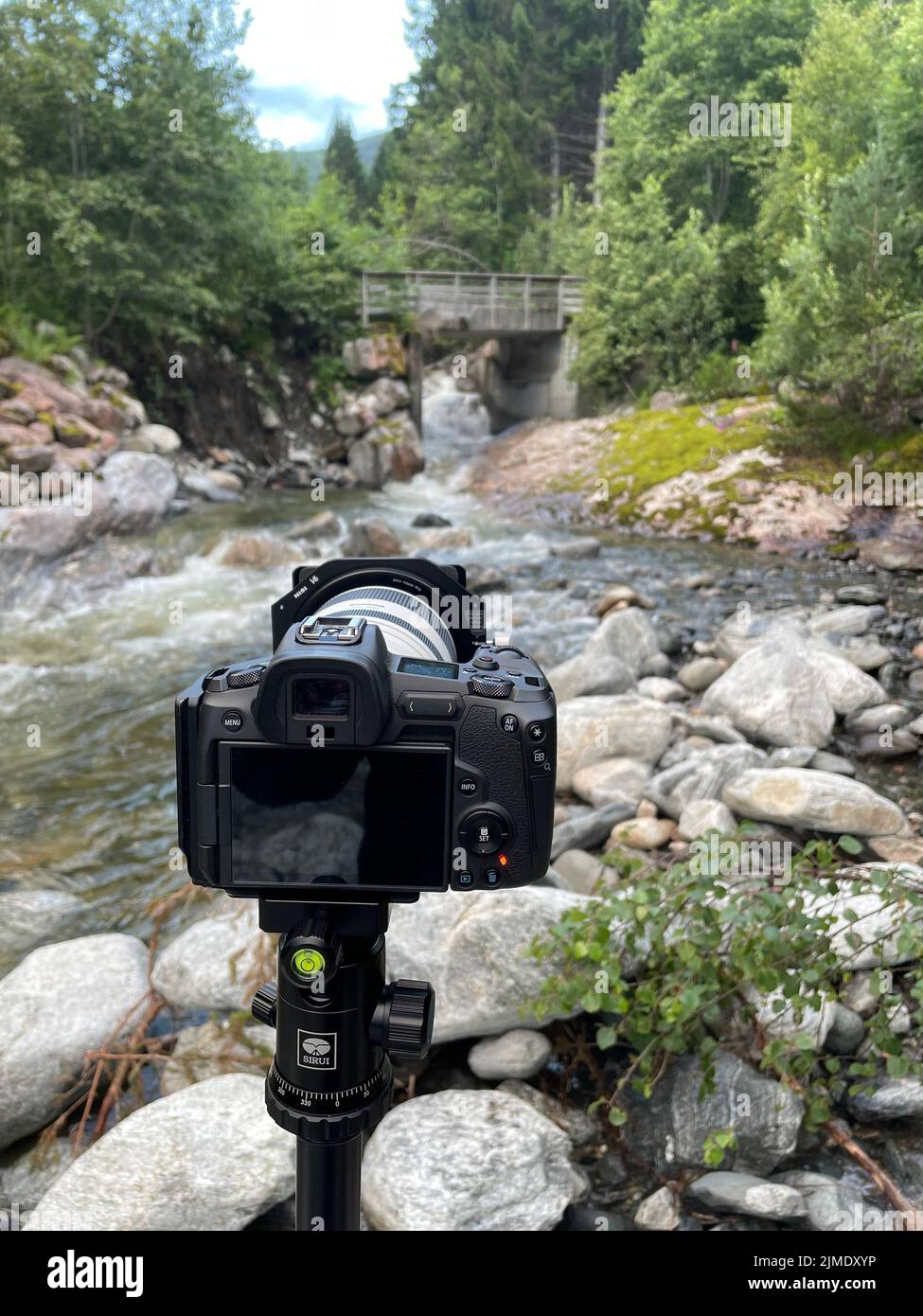 A vertical shot of a professional camera, filming nature and a rocky ...