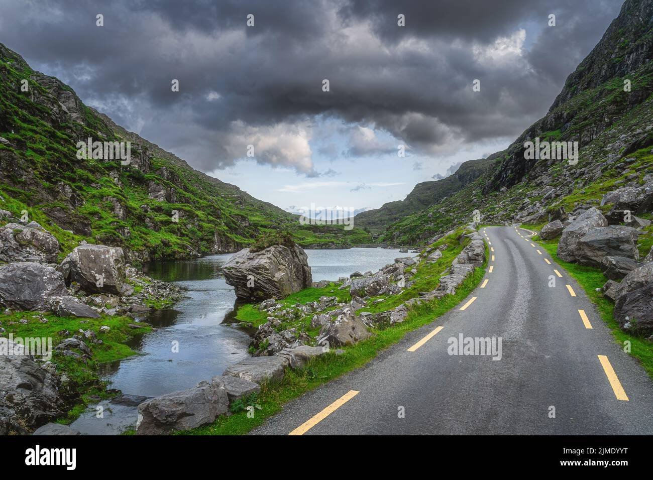 Winding road running through Gap of Dunloe with stone Wishing Bridge in ...