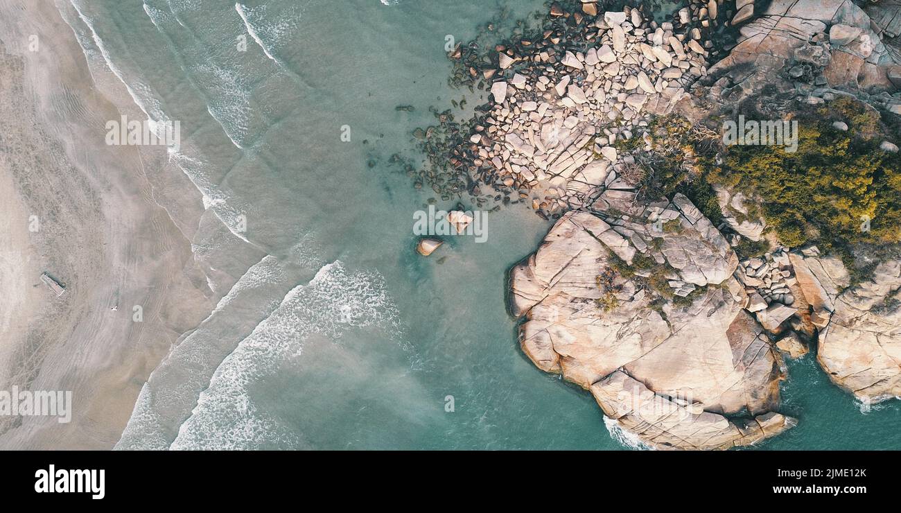 An aerial view of rocks and stones on the peaceful sandy shore Stock ...