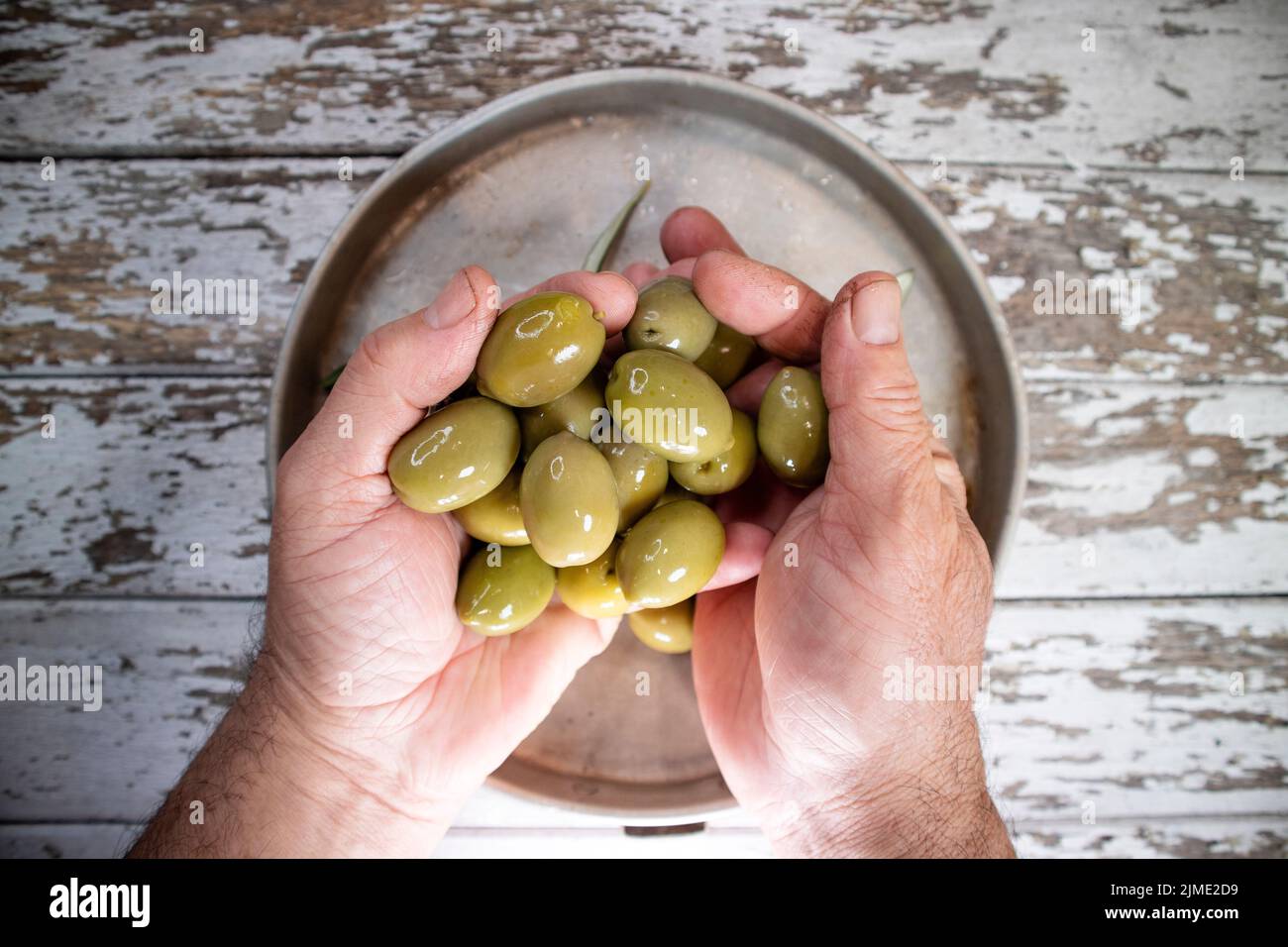 Group of green olives in hand Stock Photo - Alamy