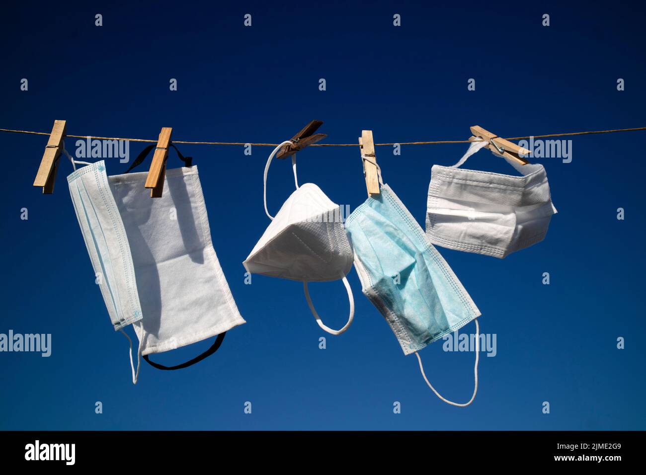 Group of mixed anti Covid masks hung out to dry Stock Photo - Alamy
