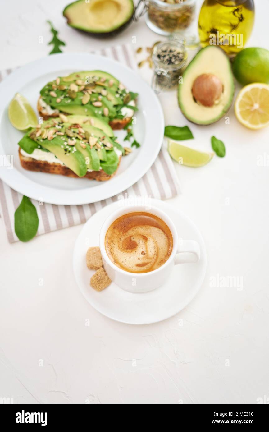 Freshly made Avocado and cream cheese toasts on a white ceramic plate ...