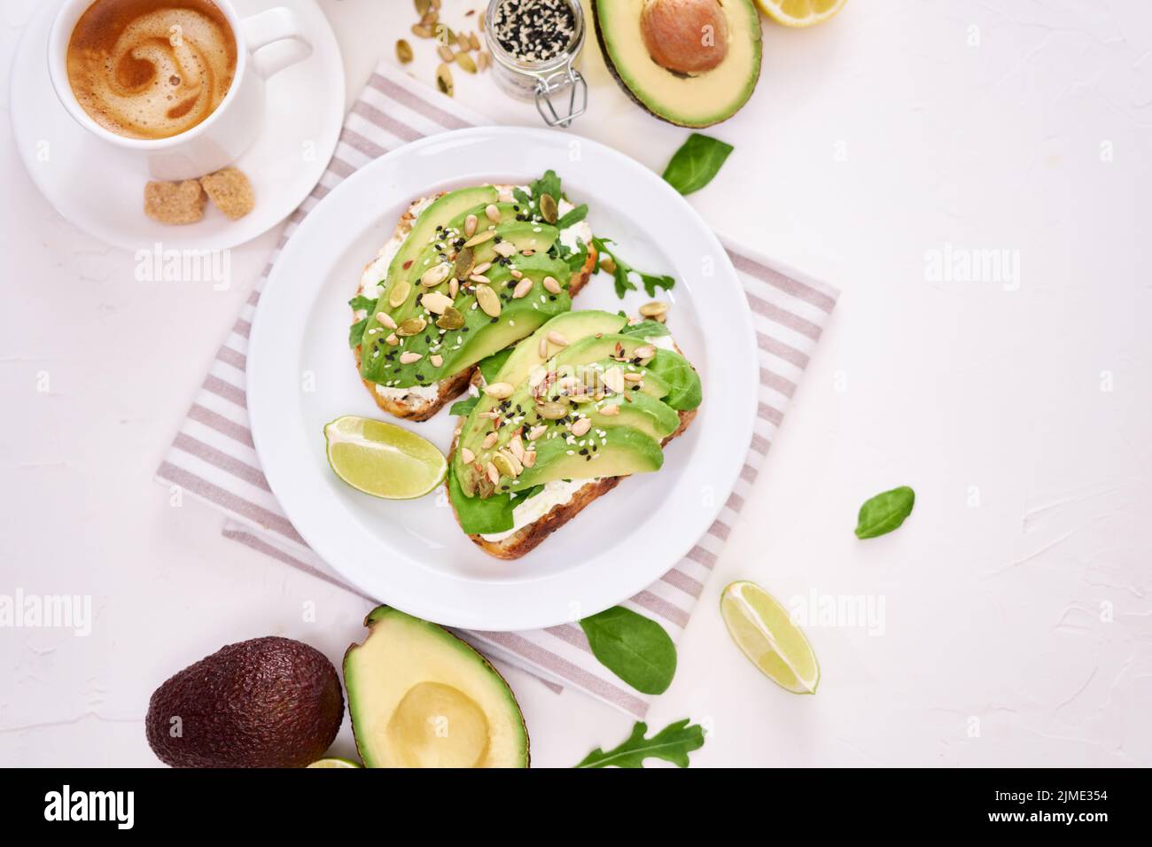 Freshly made Avocado and cream cheese toasts on a white ceramic plate ...
