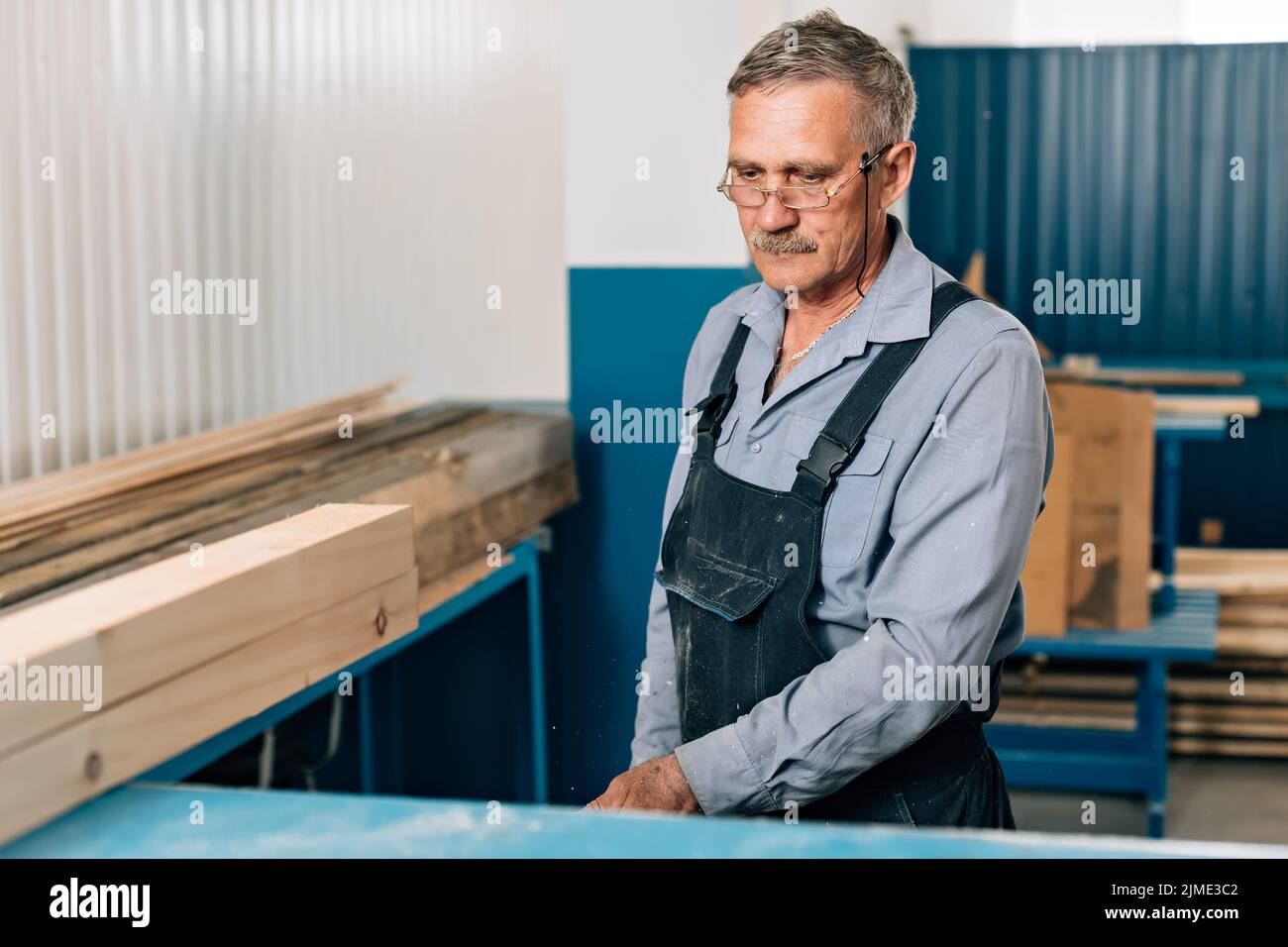 Portrait of an elderly carpenter or carpenter working with wooden ...