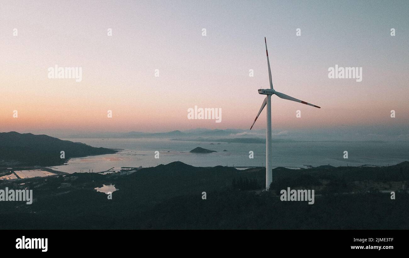 A wind turbine by the seashore at the sunrise scenery background Stock ...