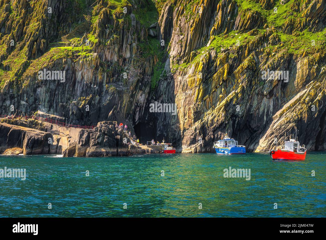 Boats docking to per on Skellig Michael island, tourists on and of ...