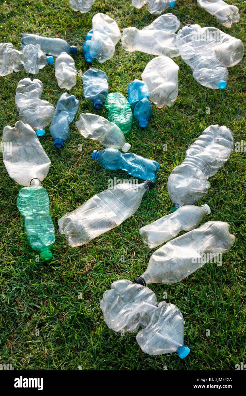 Used plastic bottles abandoned in a meadow Stock Photo - Alamy