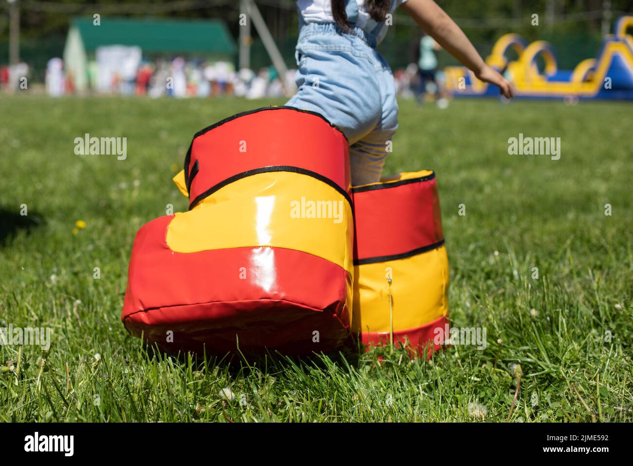 Child in inflatable boots. The kindergartner plays at the party Stock ...