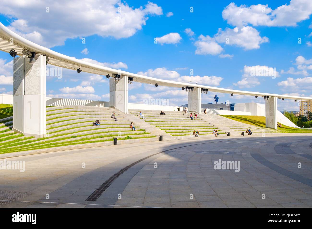 People relax in a modern recreation area among abstract architectural ...