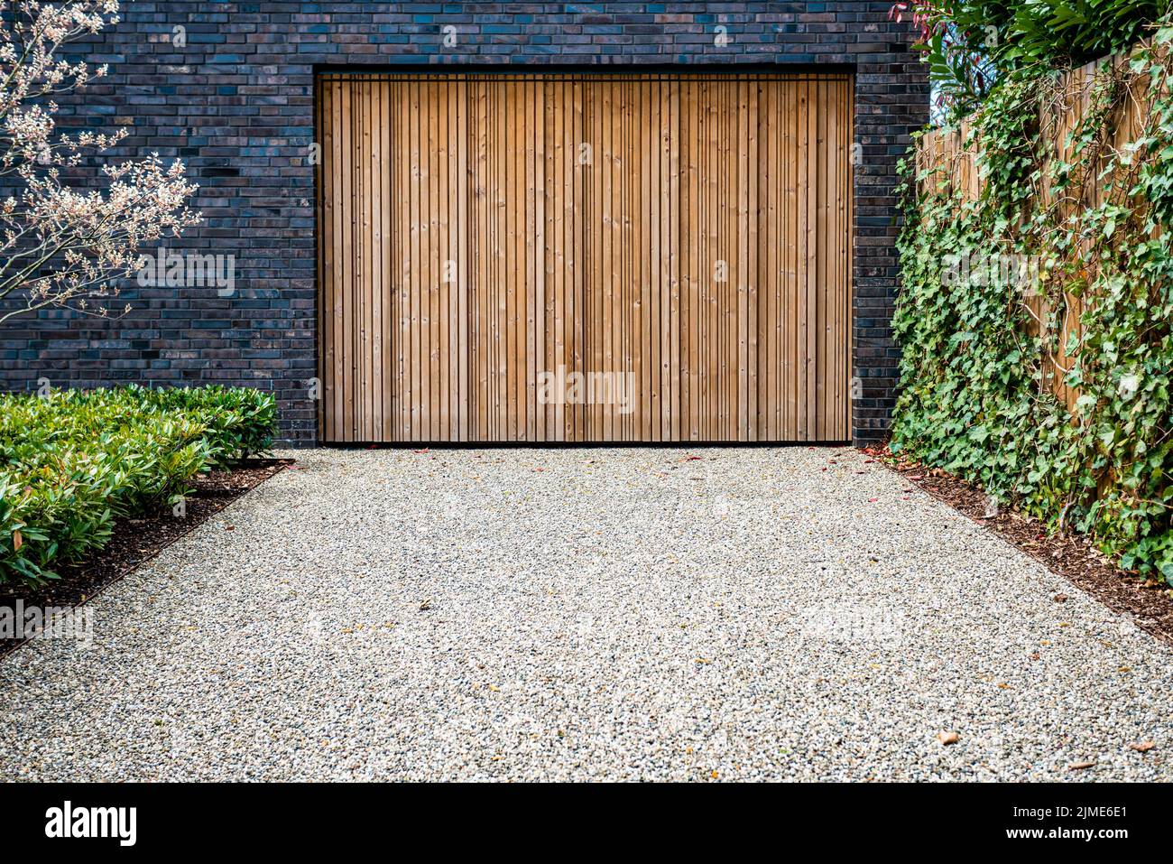 Wide garage door and concrete driveway in front Stock Photo - Alamy