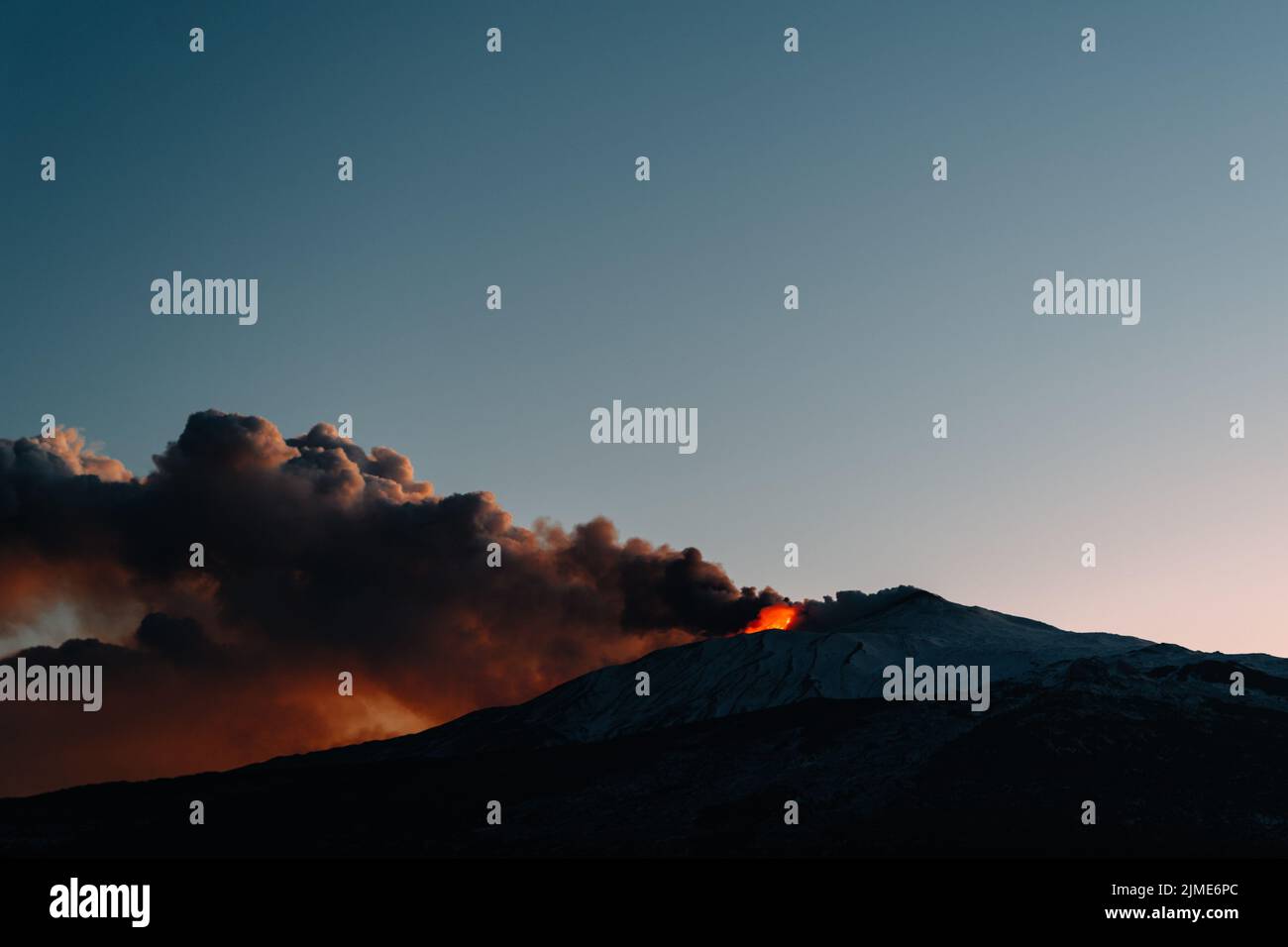 A view of active volcano with fire, very hot lava, and thick red smoke ...