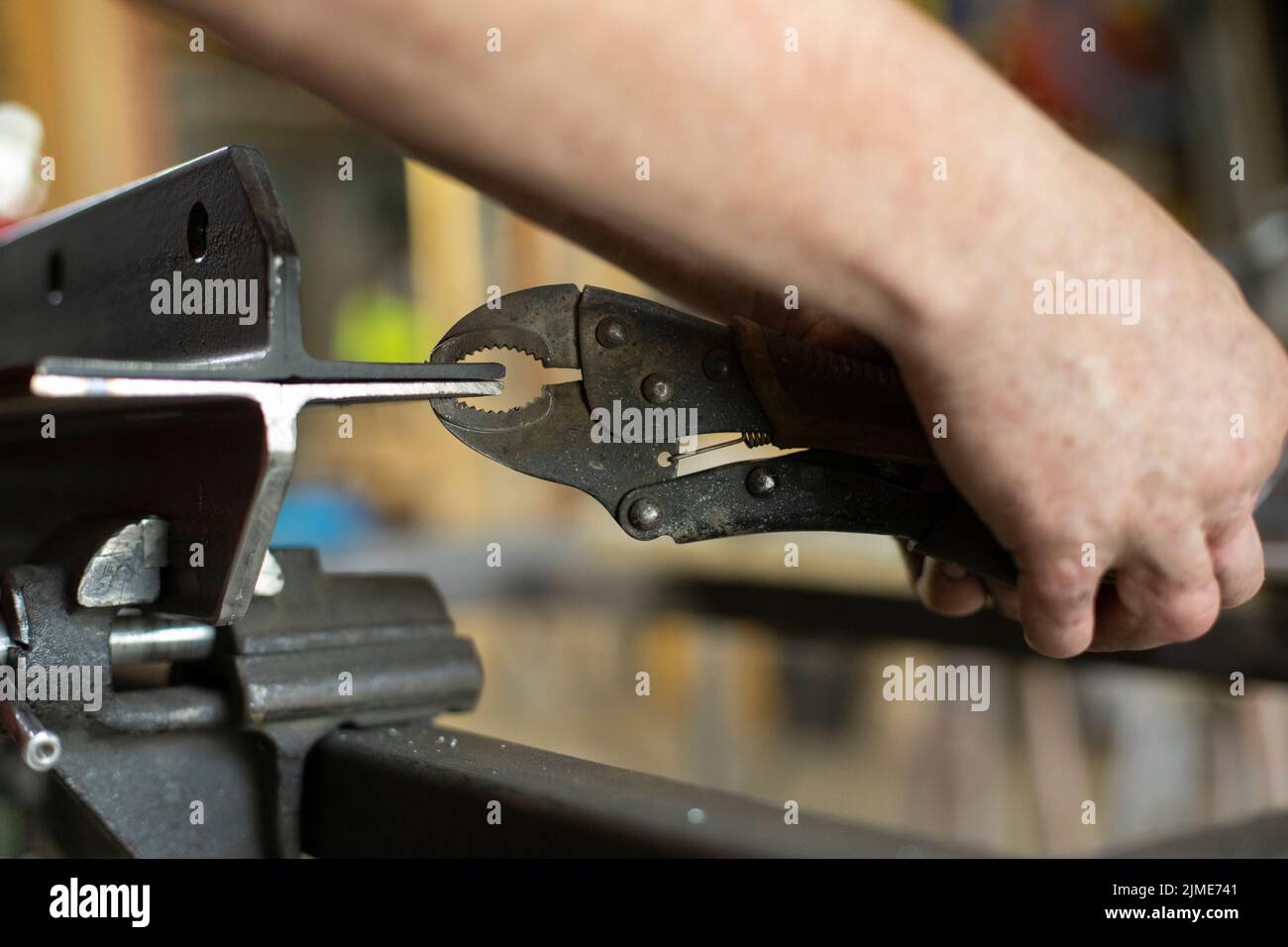 Fixing the part with forceps. A man prepares metal for processing Stock ...