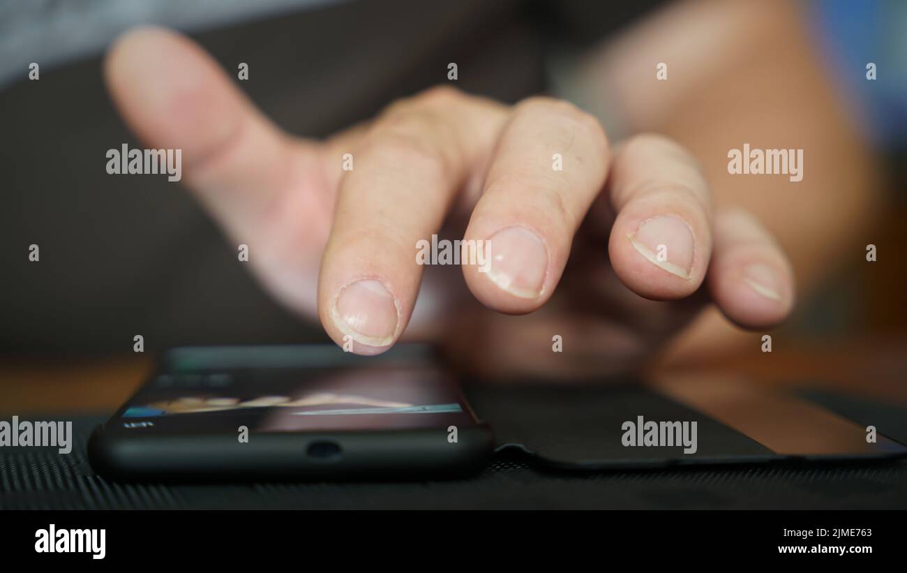Fingers of a person operate a smartphone lying on the table Stock Photo ...