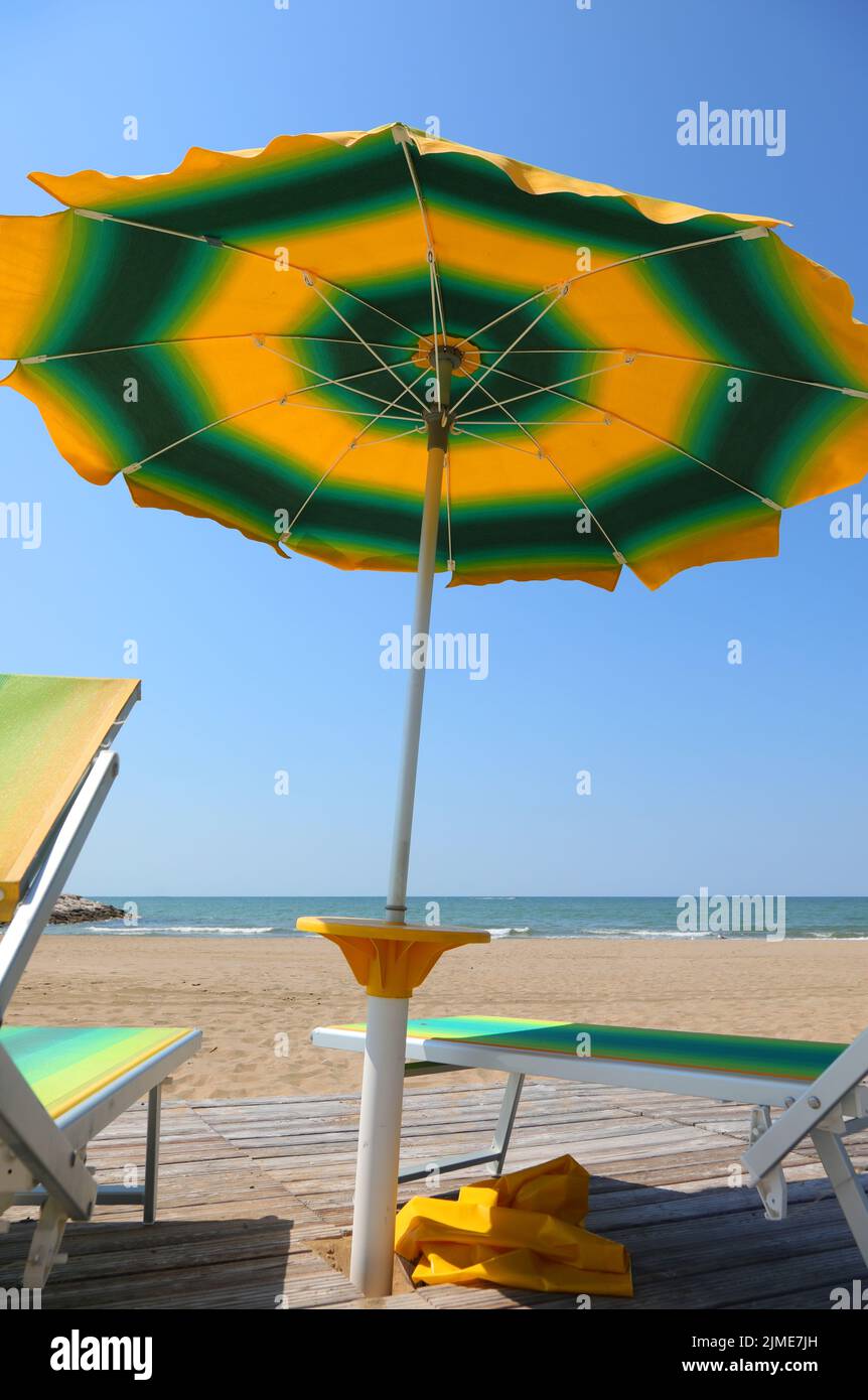 under a large yellow-green umbrella and you lay down by the sea in ...