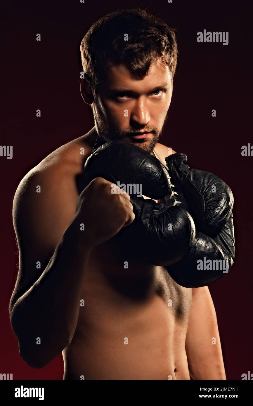 Portrait of a confident fighter on a dark background with a straight ...