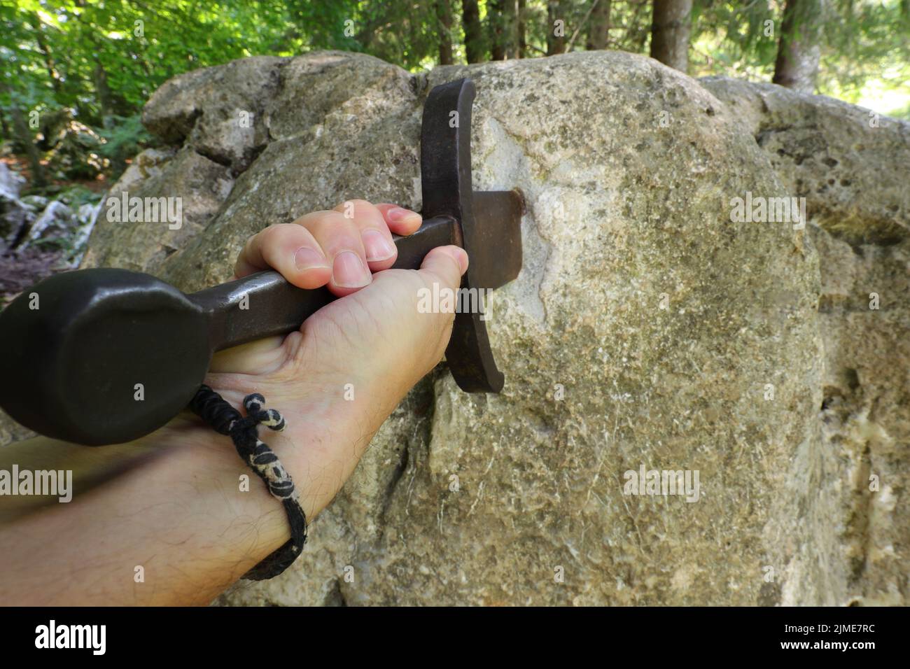 hand of knight and sword in the stone as in the legend of King Arthur ...