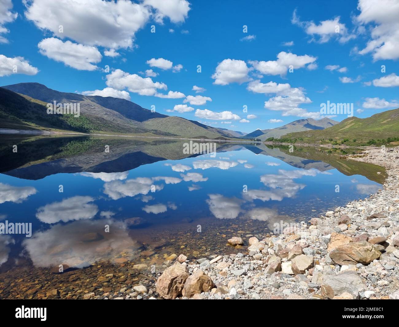 The scenic view of hills and clouds reflection on the lake water in ...