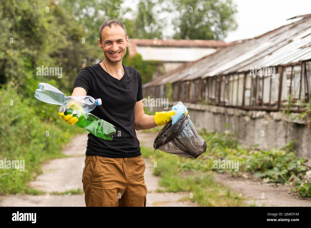 young man picking up trash outdoor. close up Stock Photo - Alamy