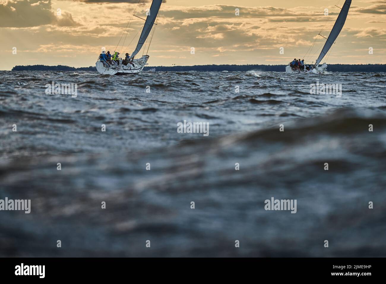 Competition of two sailboats on the horizon in sea at sunset, the ...