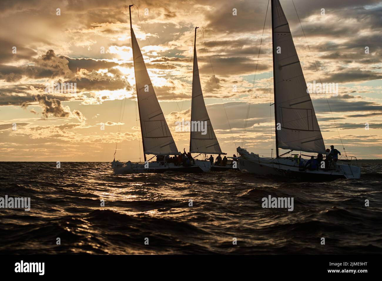 Competition of Three sailboats on the horizon in sea at sunset, the ...