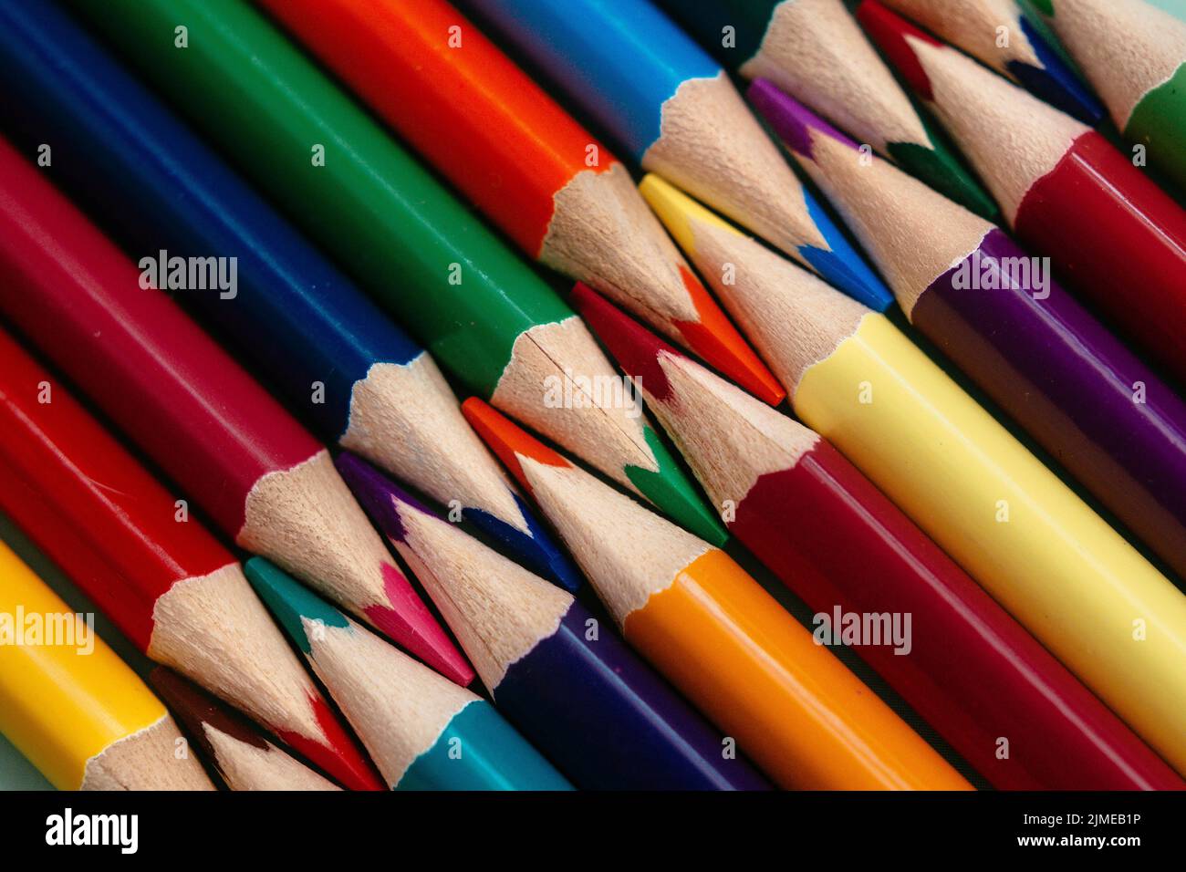 Colored sharpened pencils lie in a row close-up. Solid abstract ...