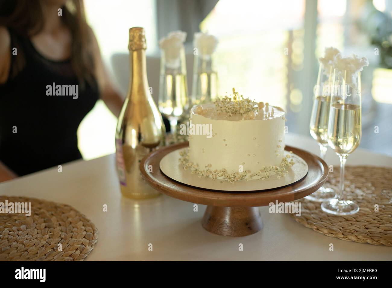 White cake. Sweet cake and glasses of champagne. Cake on table ...