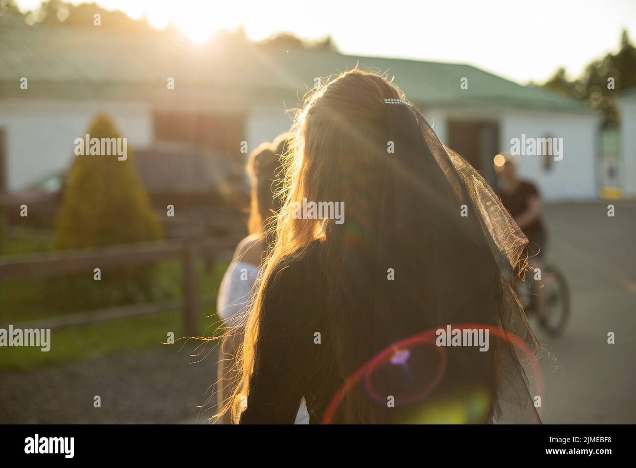 Girl in sunlight. Long hair in bright rays of sun. Woman on street in ...