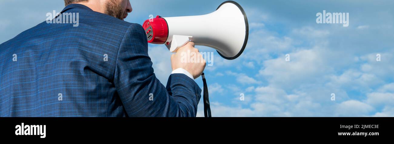 back cropped view of businessman shout in loudspeaker on sky background ...