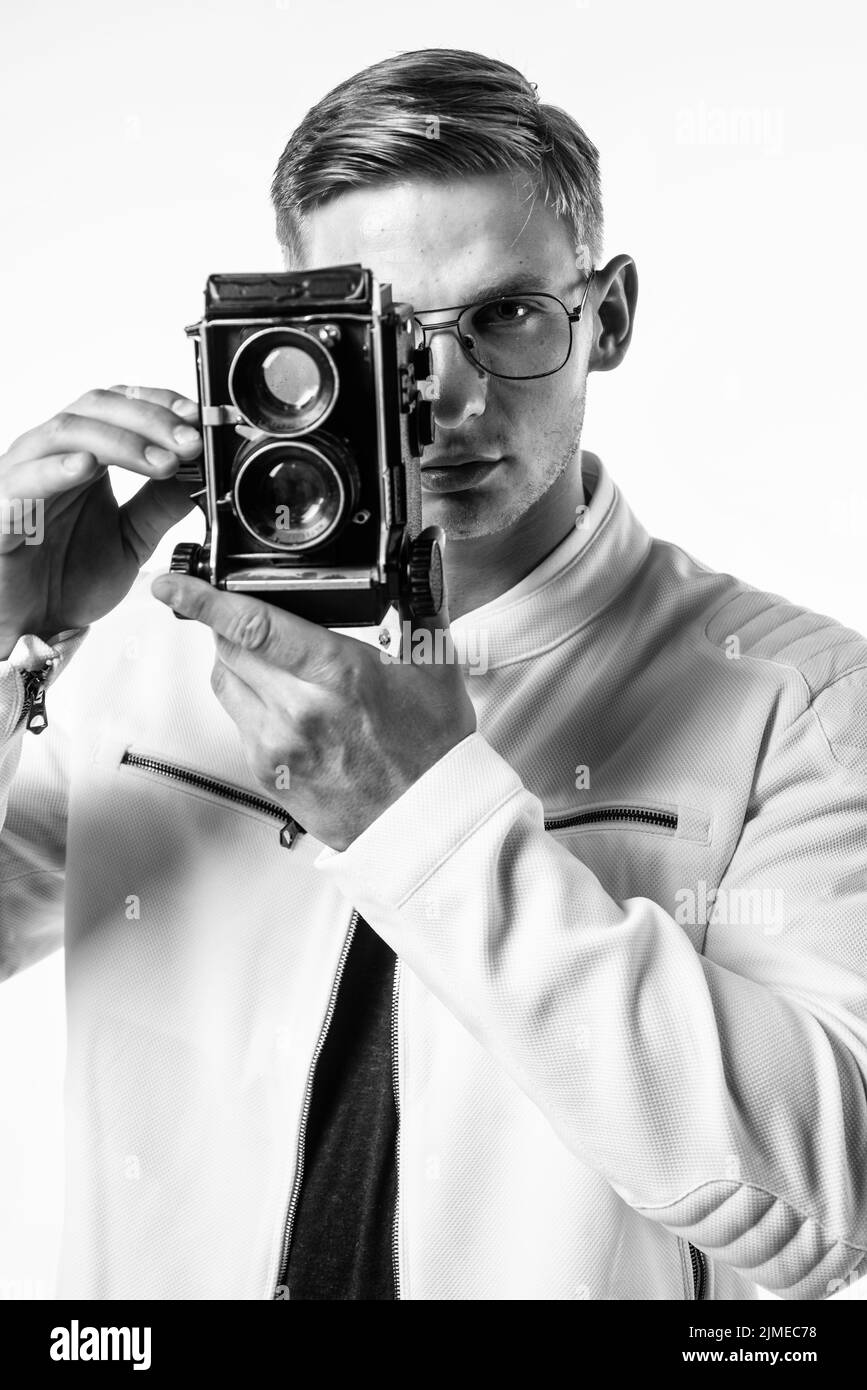 Young photographer take photograph looking in eye of retro camera ...