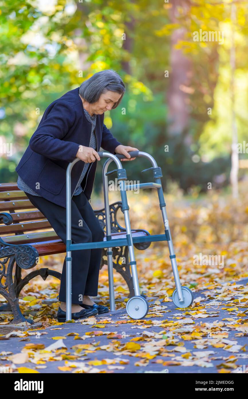 Woman with walker walking outdoors Stock Photo - Alamy