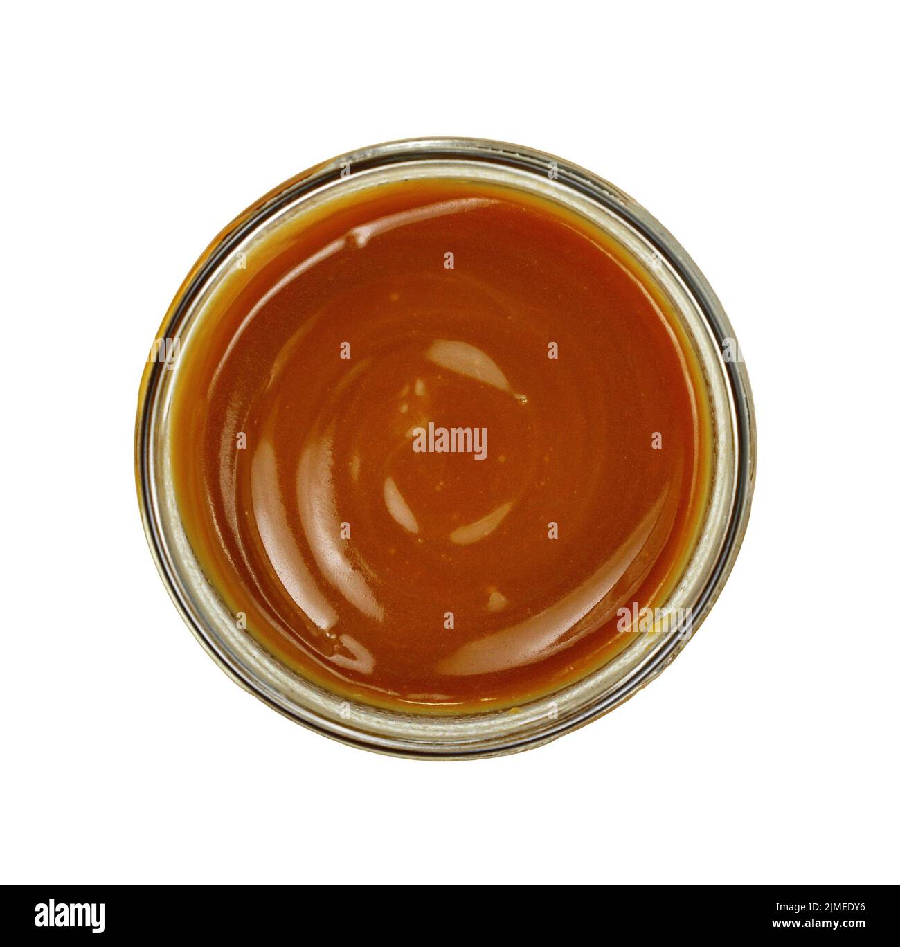 Sweet caramel sauce in a transparent bowl isolated on white background ...