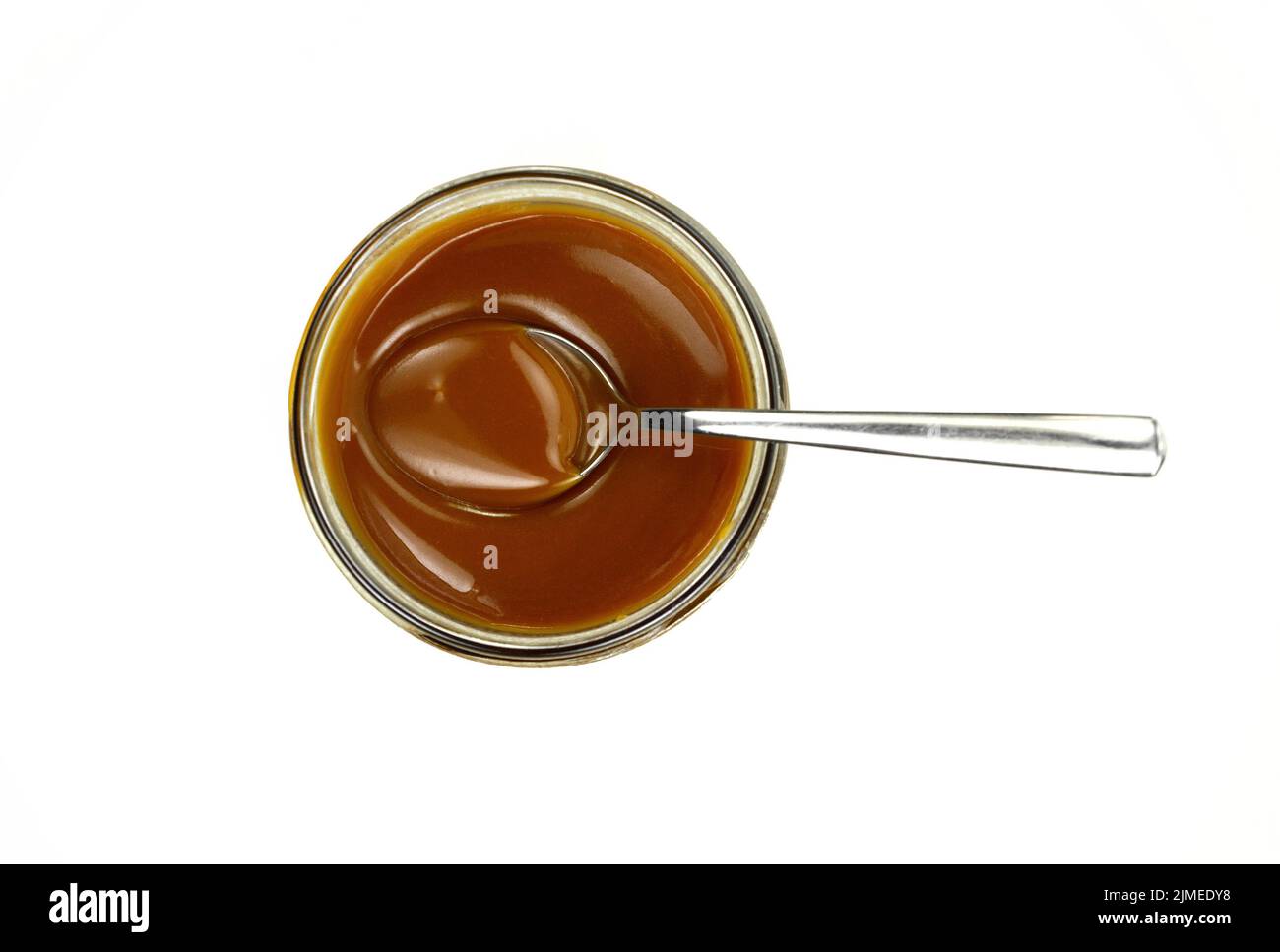 Sweet caramel sauce in a transparent bowl isolated on white background ...
