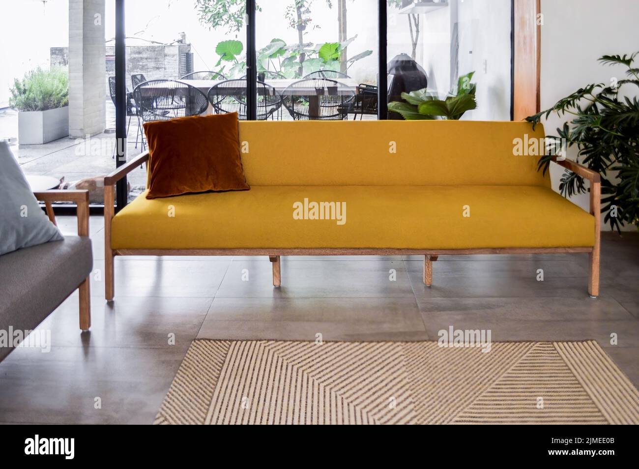 A modern room interior with yellow cozy Scandinavian style sofa, and ...
