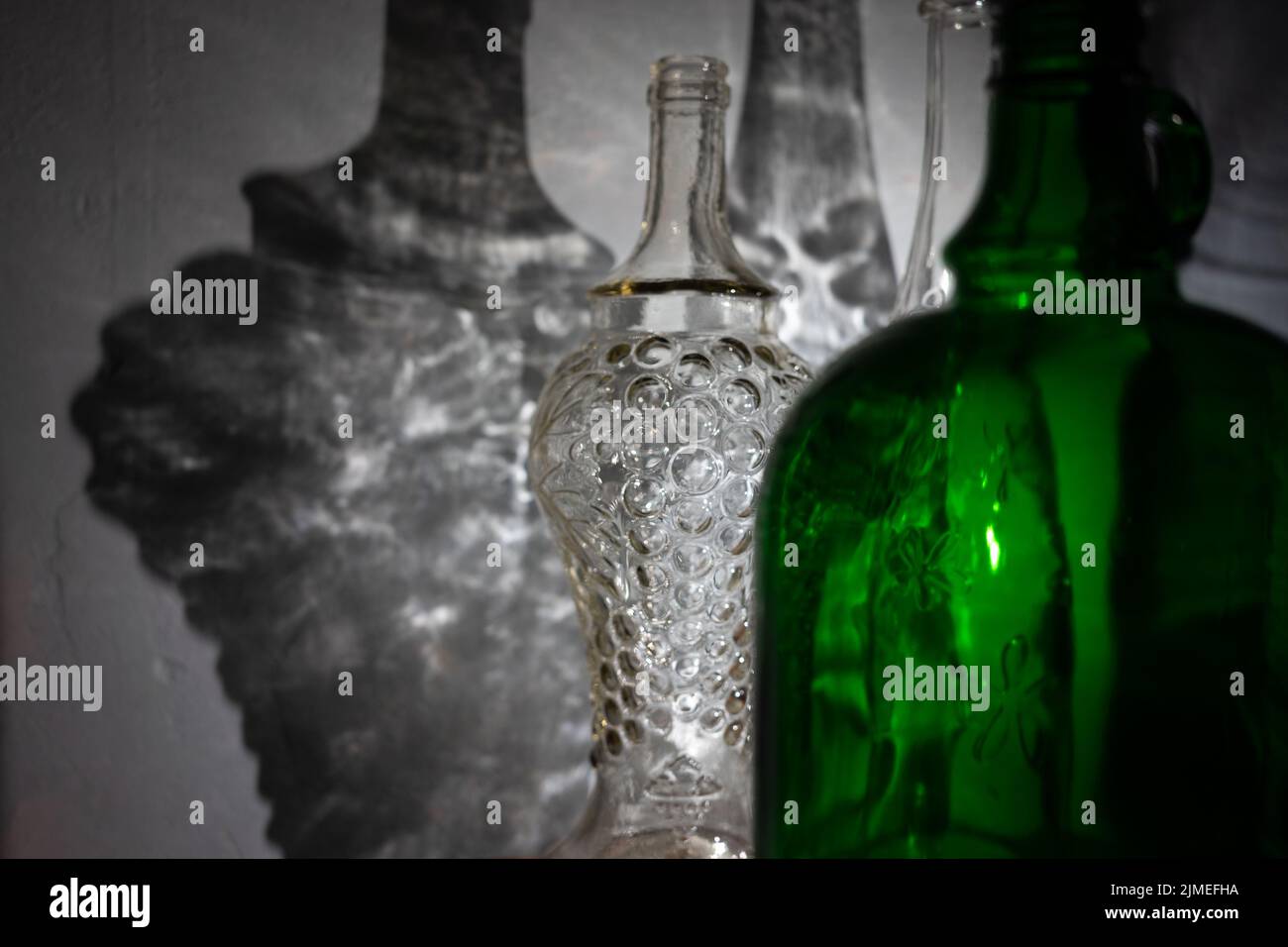 Abstract image of shaped glass bottles with a bright reflection on the ...