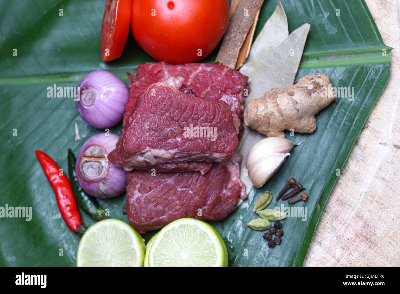 cow beef with spice and sliced lemon and tomato on banana leaf Stock ...