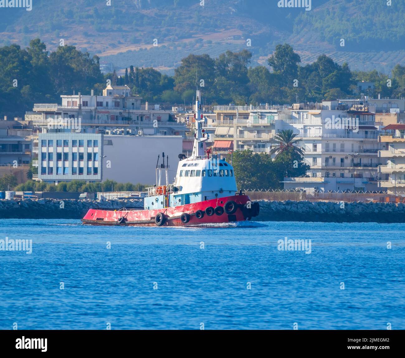 Red Tugboat and Sunny Summer Coast With Town Stock Photo - Alamy