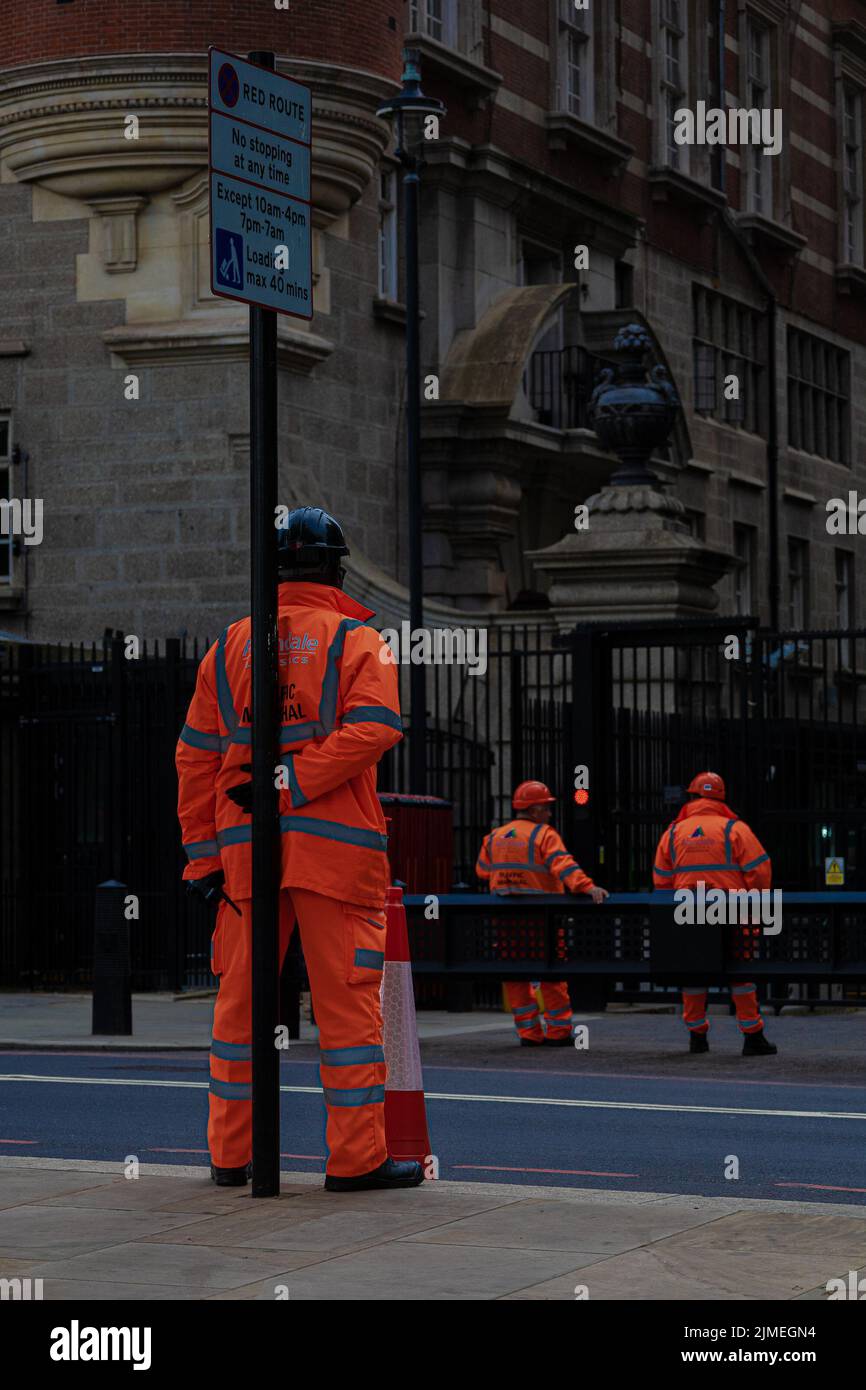 A vertical shot of the workers with orange uniforms during construction works Stock Photo - Alamy