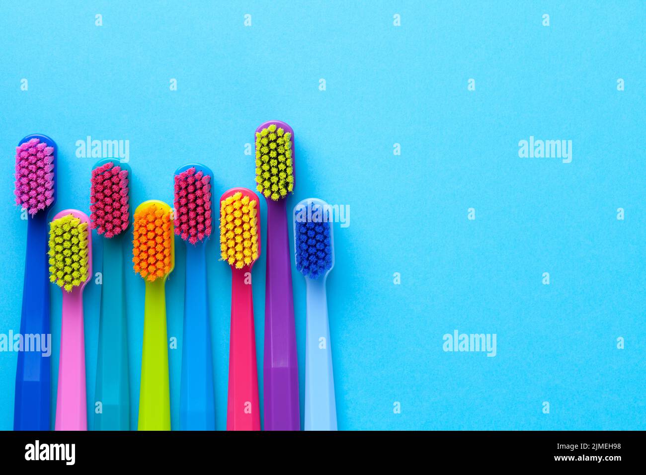 Colorful Toothbrushes Over Blue Paper Background Stock Photo - Alamy