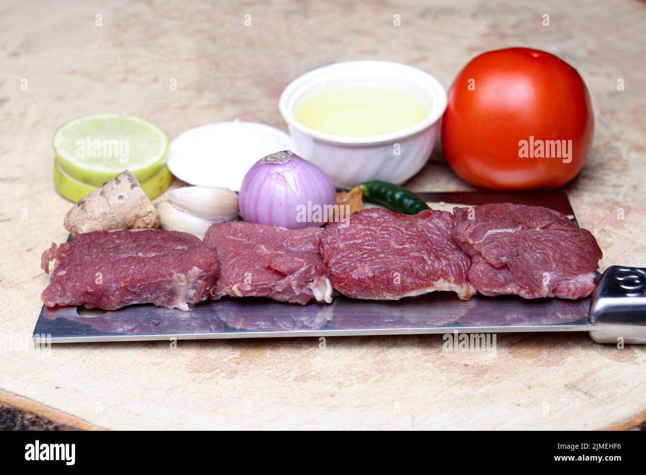 cow beef with spice and sliced lemon and tomato on chopping board Stock ...