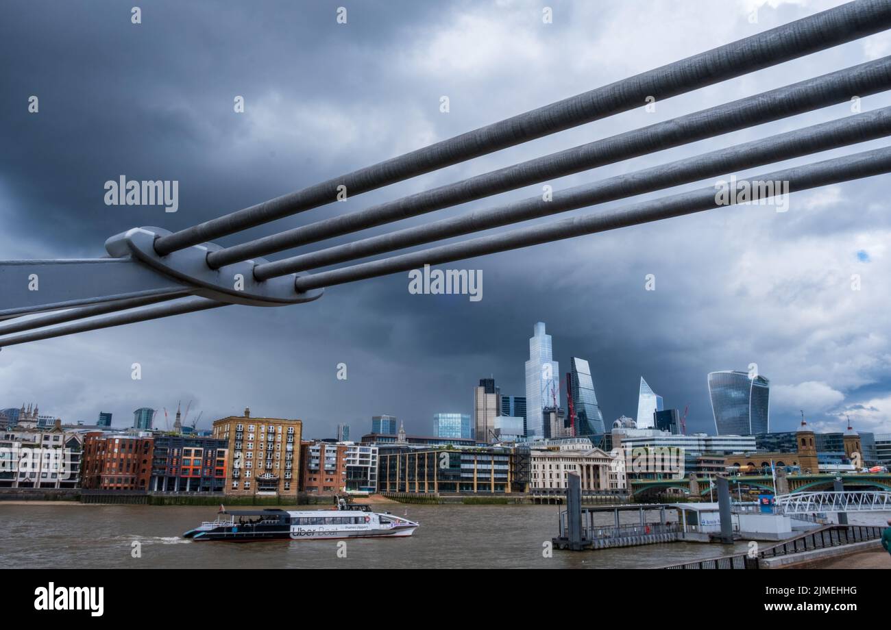 A boat travels on river Thames past the Millennium footbridge with the ...